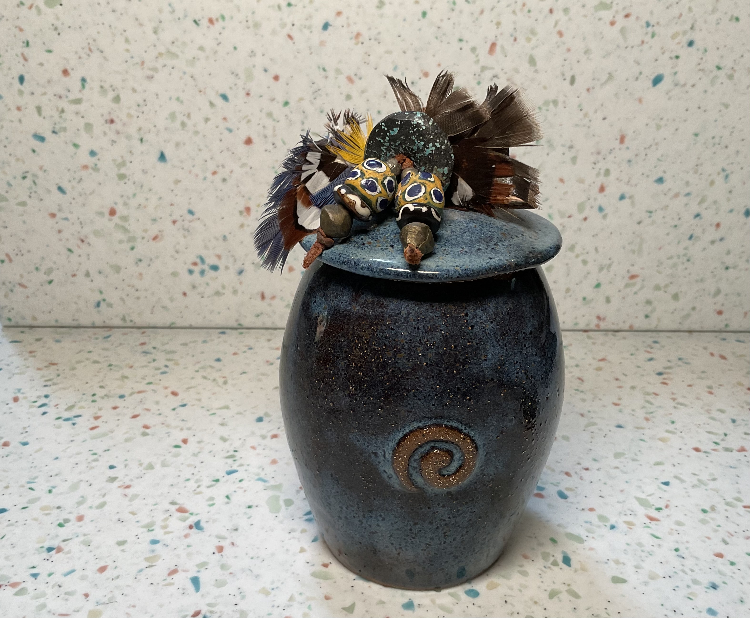 Studio pottery jar with lid embellished with clay beads, wood, & feathers