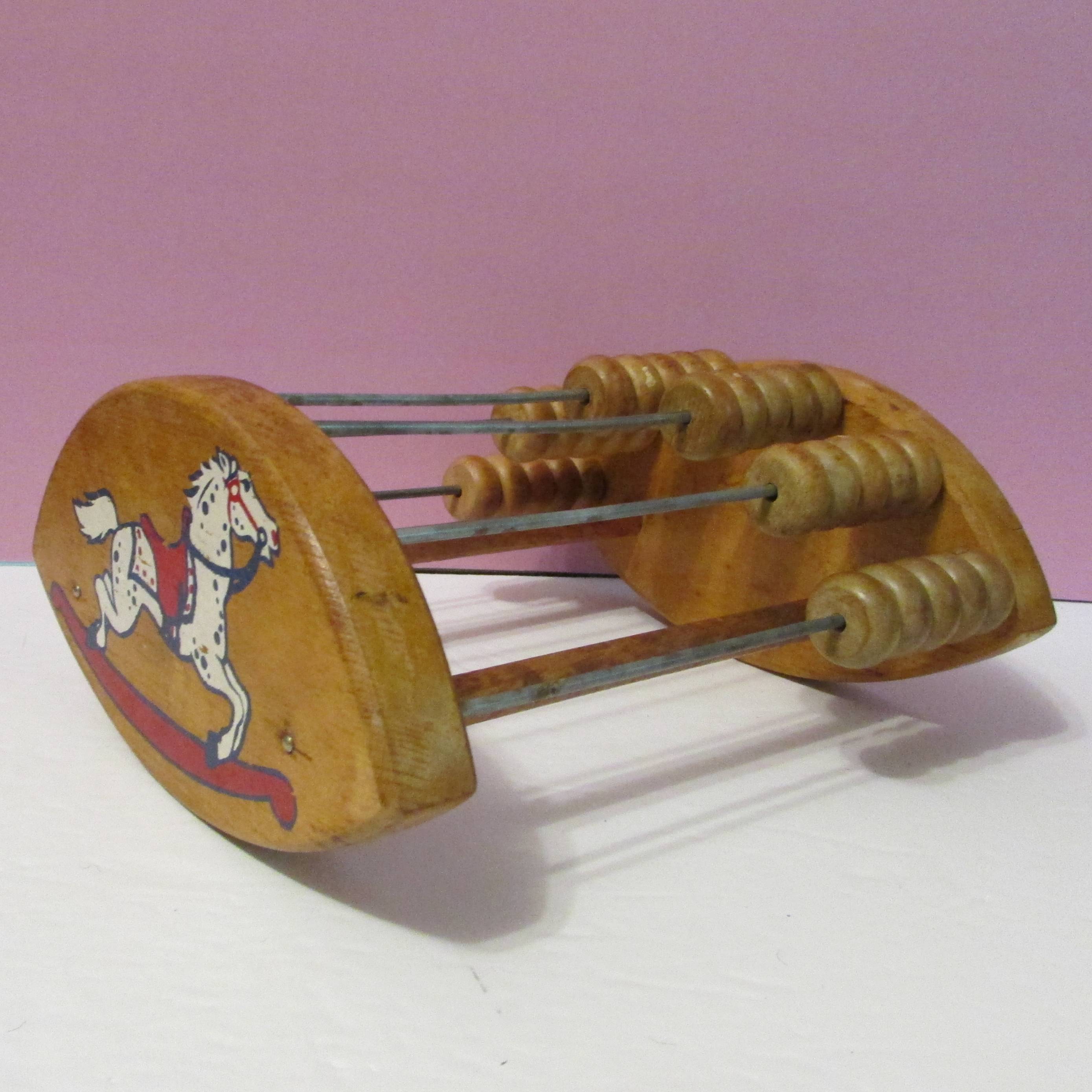 vintage wooden teetering sliding bead toy with painted rocking horse design