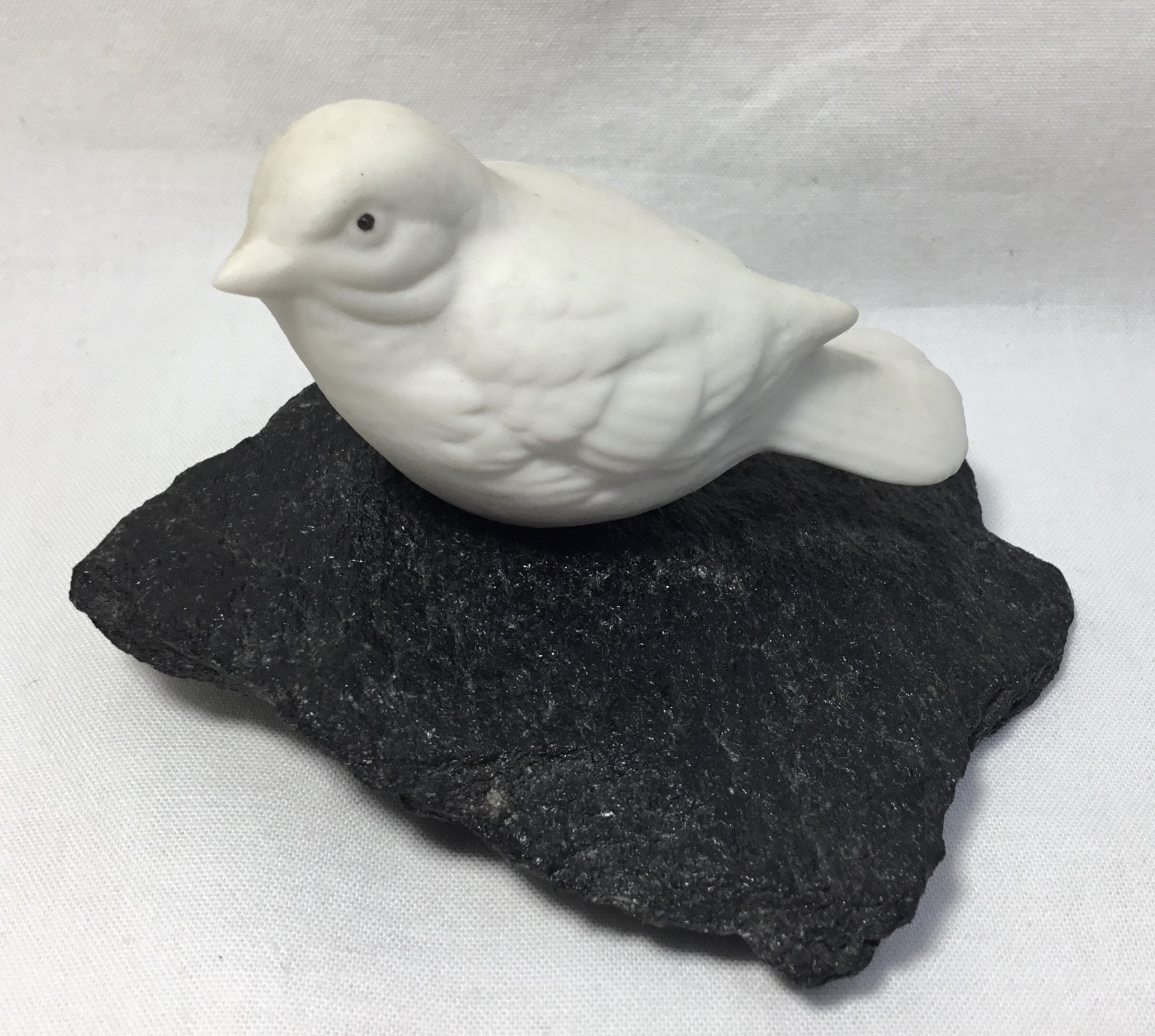 Porcelain figurine, white bird on black basalt rock, signed by artist