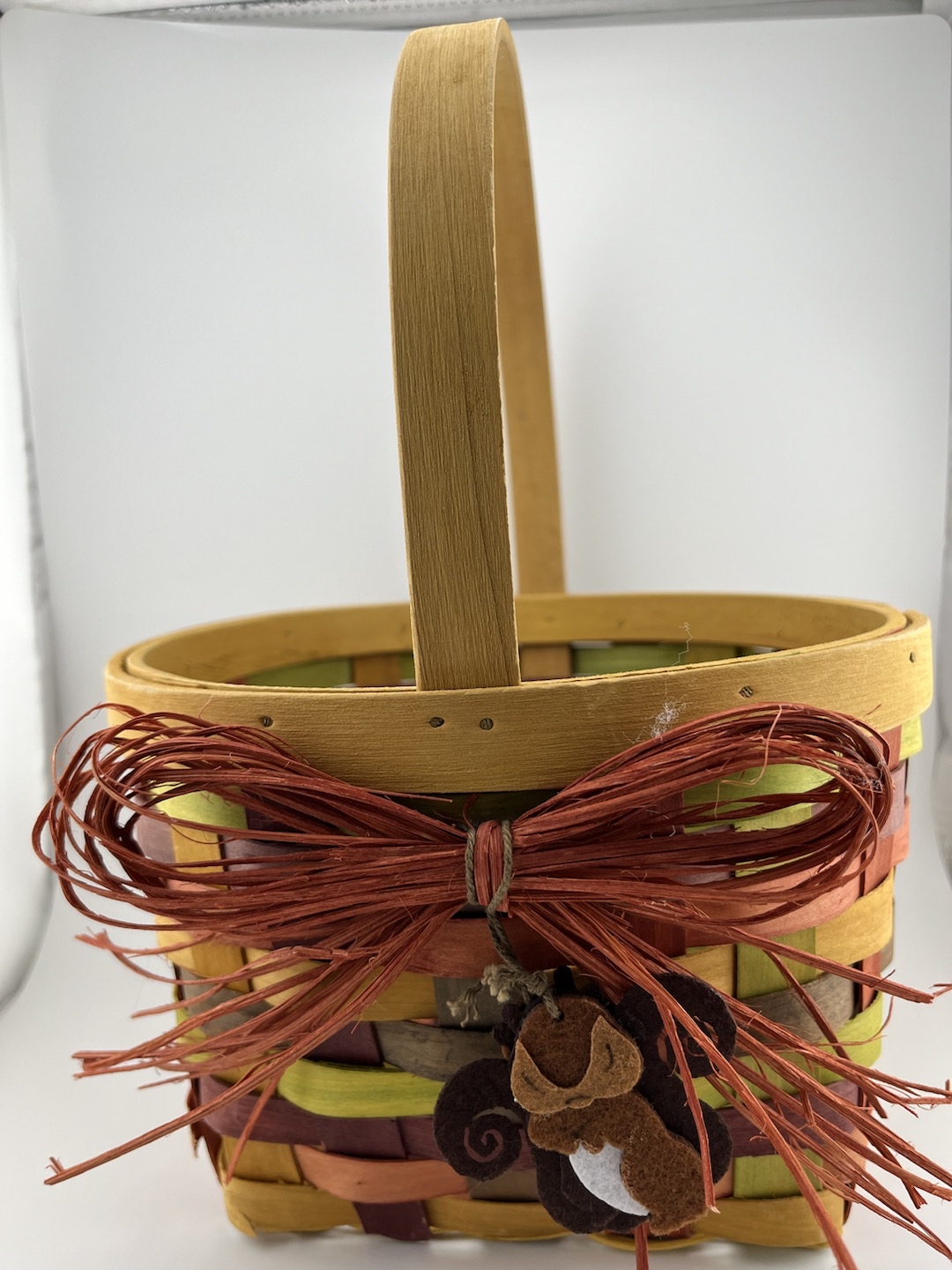 Wooden reed woven basket, fall colors, w/ Bow & Squirrel accent.