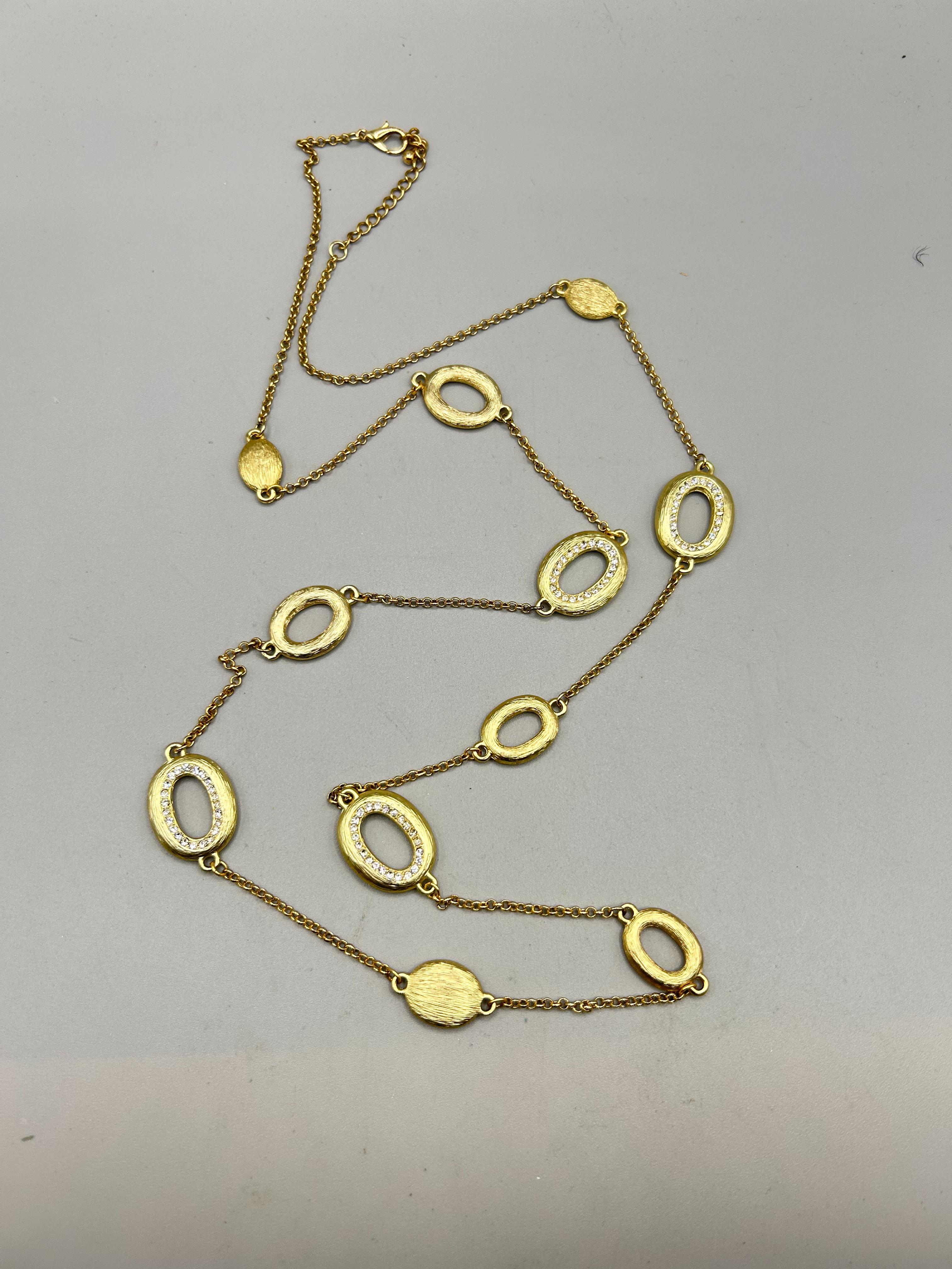 long gold tone necklace with oval spaced stations with rhinestones E1236
